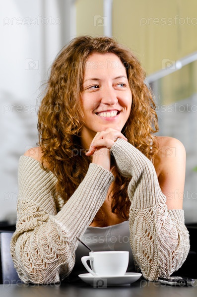 Фотография на тему Молодая счастливая женщина в кафе с чашкой кофе Pressfoto