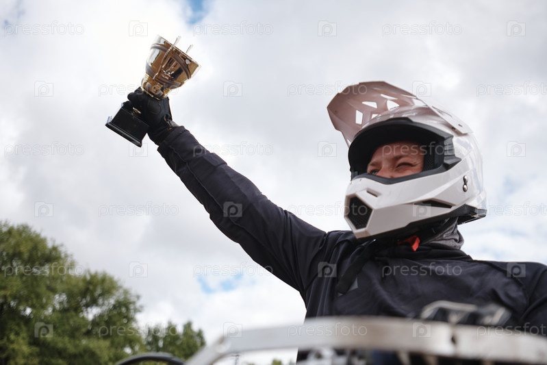 Фотография на тему Raising hand with motorcycle competition cup | PressFoto